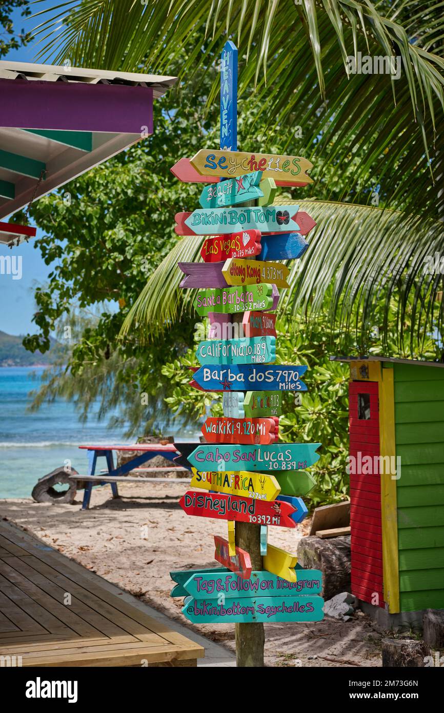 colorful information signs with distances to places around the world on ...