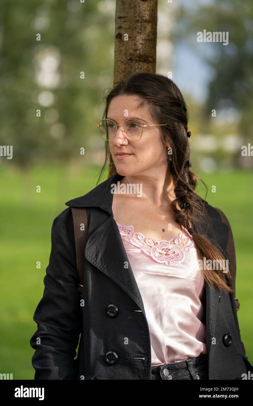 A vertical shot of a white female wearing specs and posing for the ...
