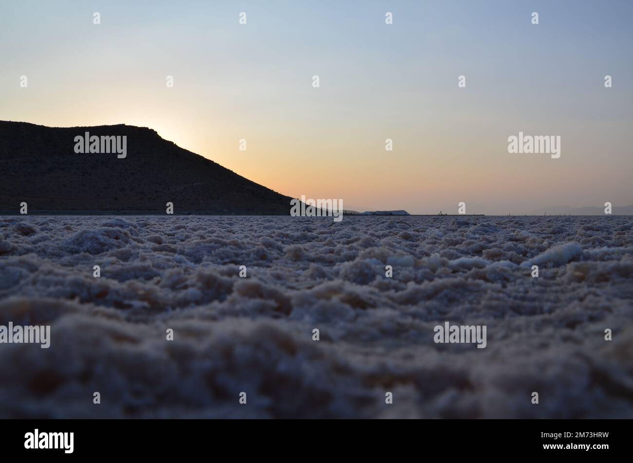 salt crystals at the surface of "pink lake" Shiraz with a mountain in ...
