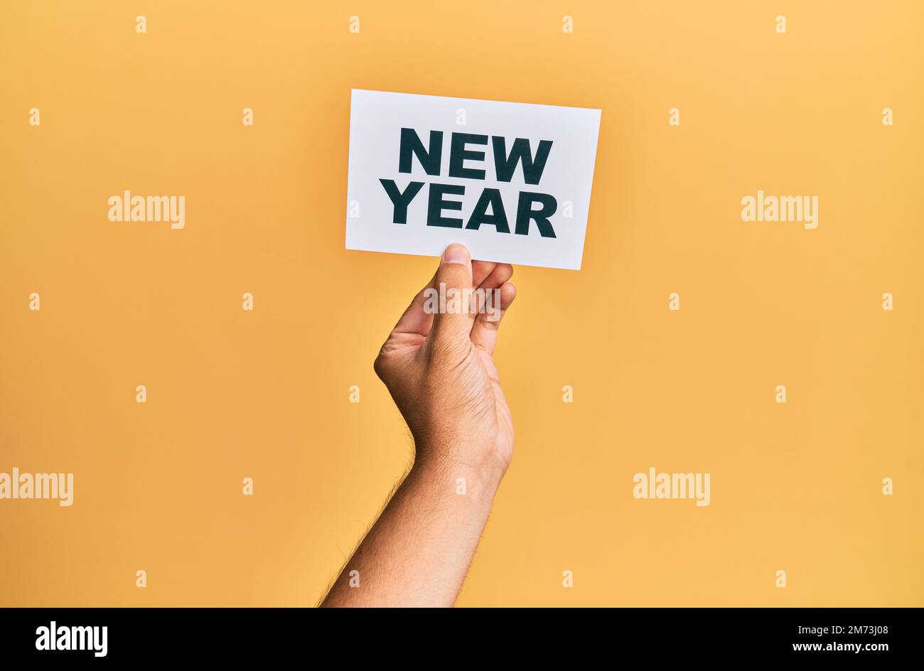Hand of caucasian man holding paper with new year message over isolated ...