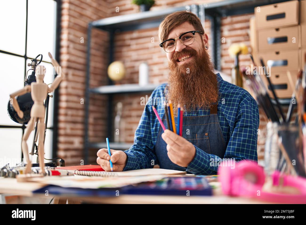 Young redhead man artist smiling confident drawing on notebook at art ...