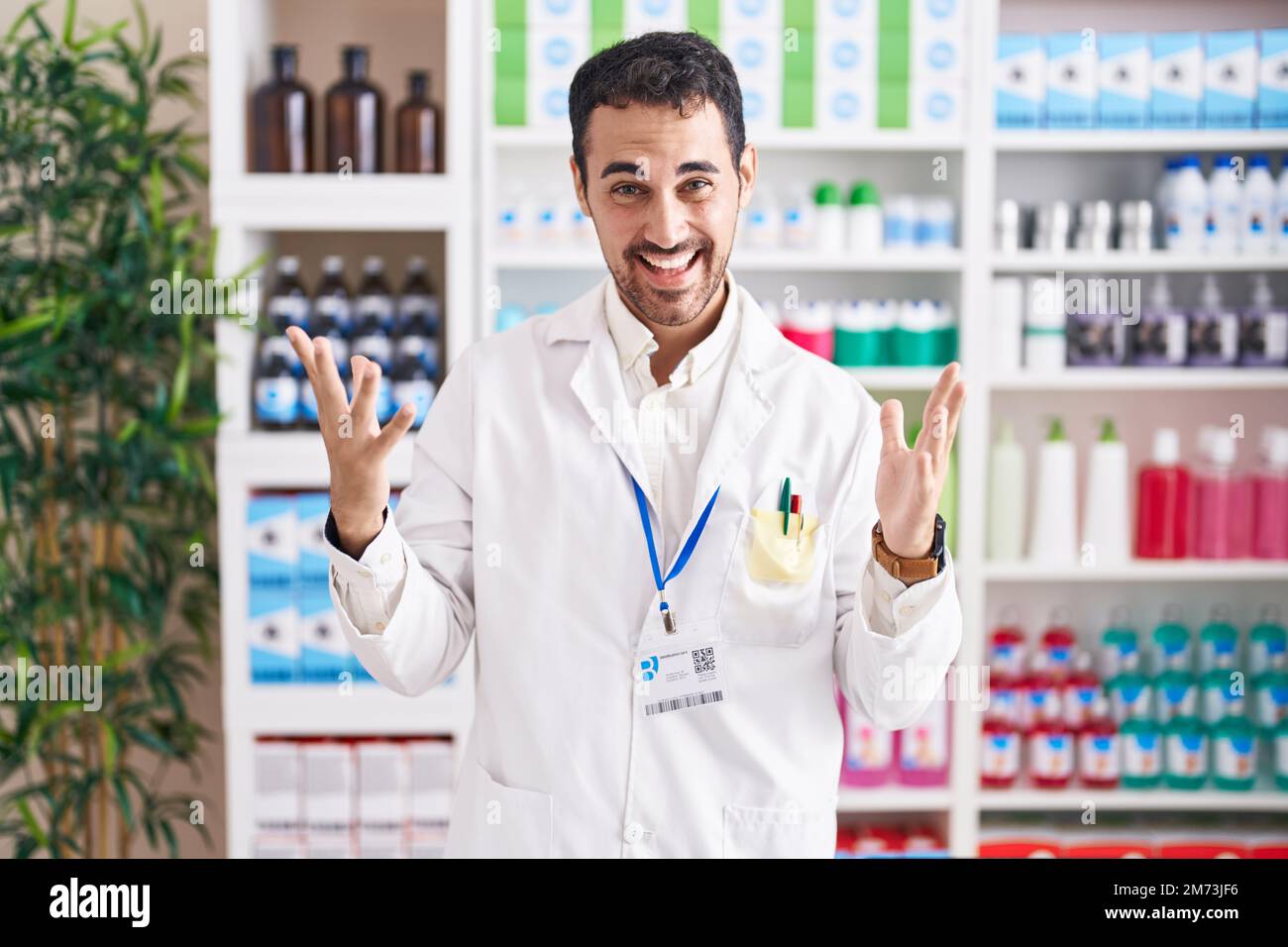 Handsome hispanic man working at pharmacy drugstore celebrating crazy ...