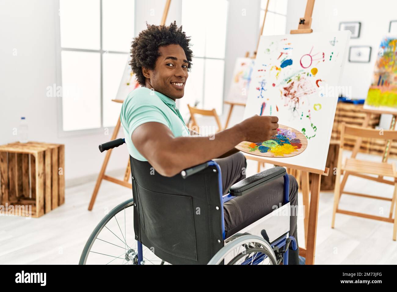Young african american disabled artist man sitting on wheelchair ...