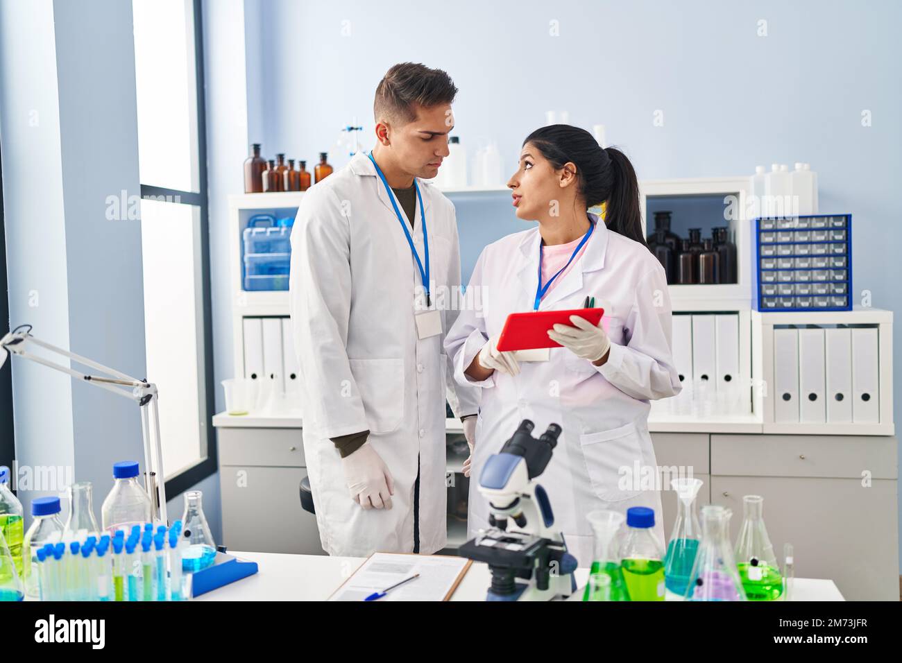 Man and woman scientists partners using touchpad at laboratory Stock ...