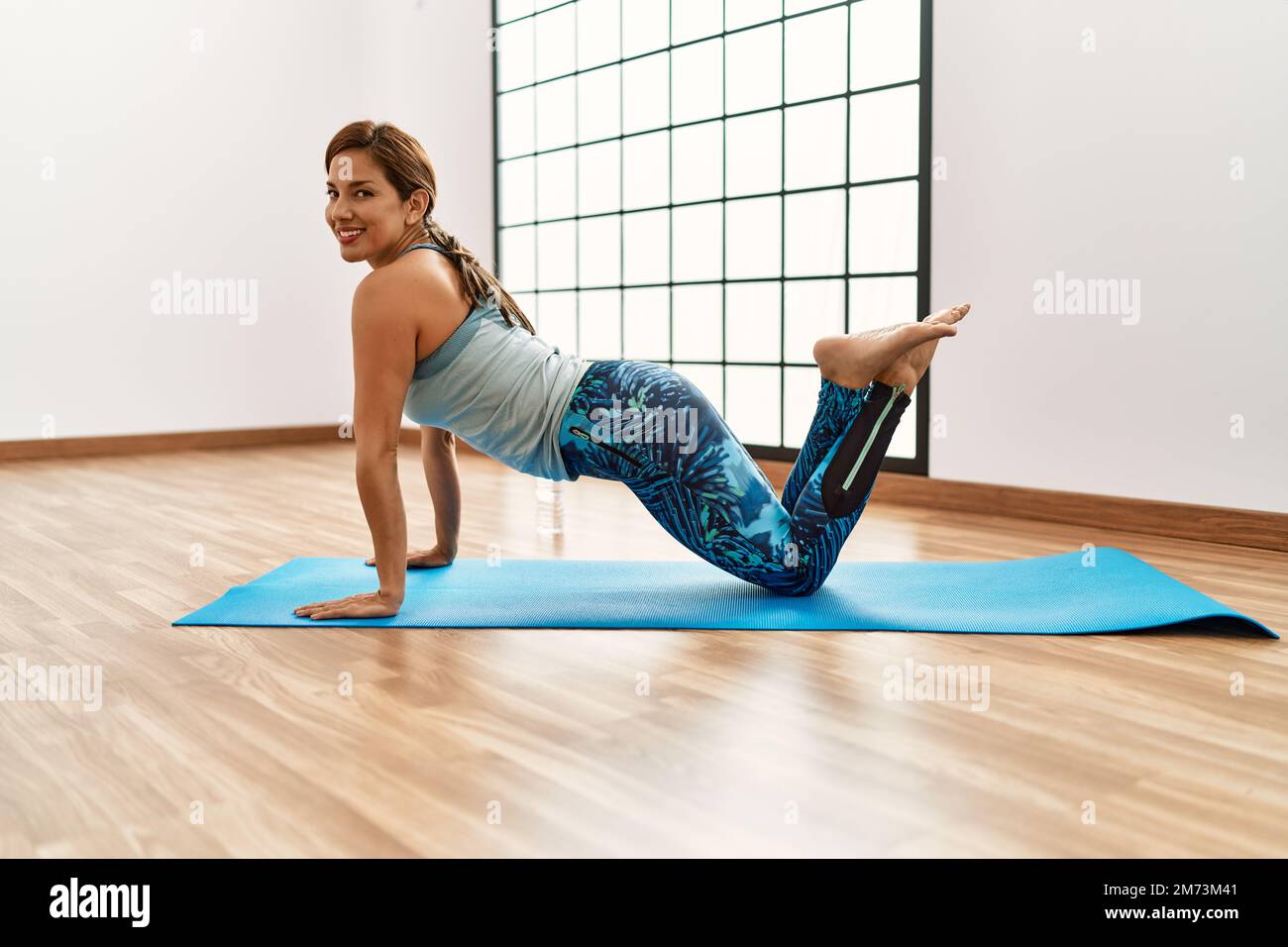 Young latin woman smiling confident training abs exercise at sport ...