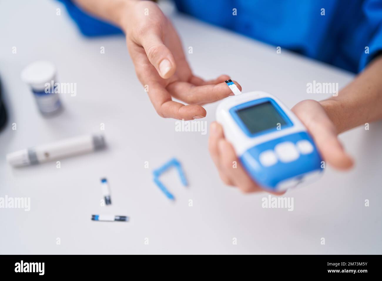 Young woman measuring glucose using glucometer at home Stock Photo - Alamy