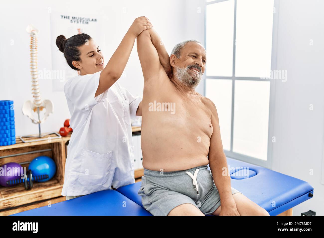 Physiotherapist and patient smiling confident having rehab session at ...