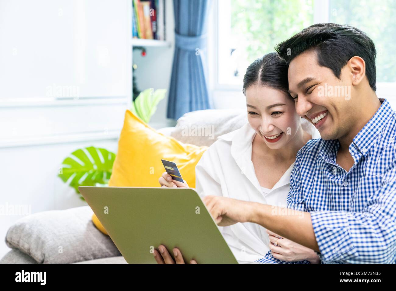 Young Asian Couple use credit card shopping on internet in the ...
