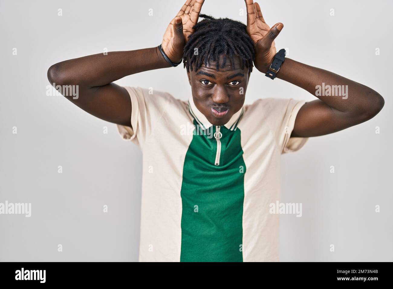 African man with dreadlocks standing over isolated background doing ...