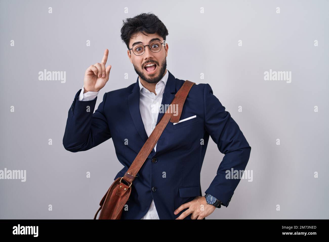 Hispanic man with beard wearing business clothes pointing finger up ...