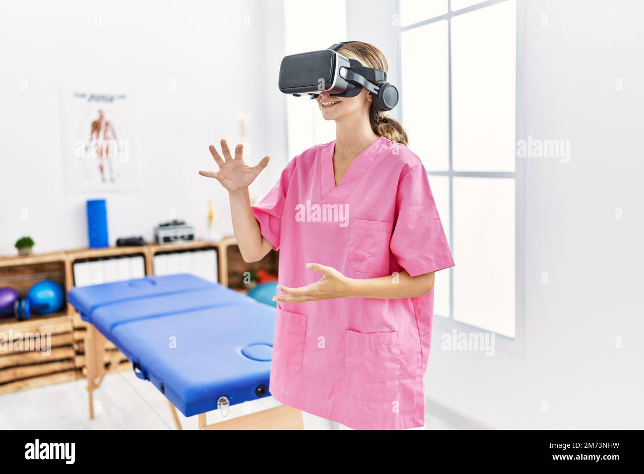 Young caucasian woman wearing physiotherapist uniform using vr glasses ...
