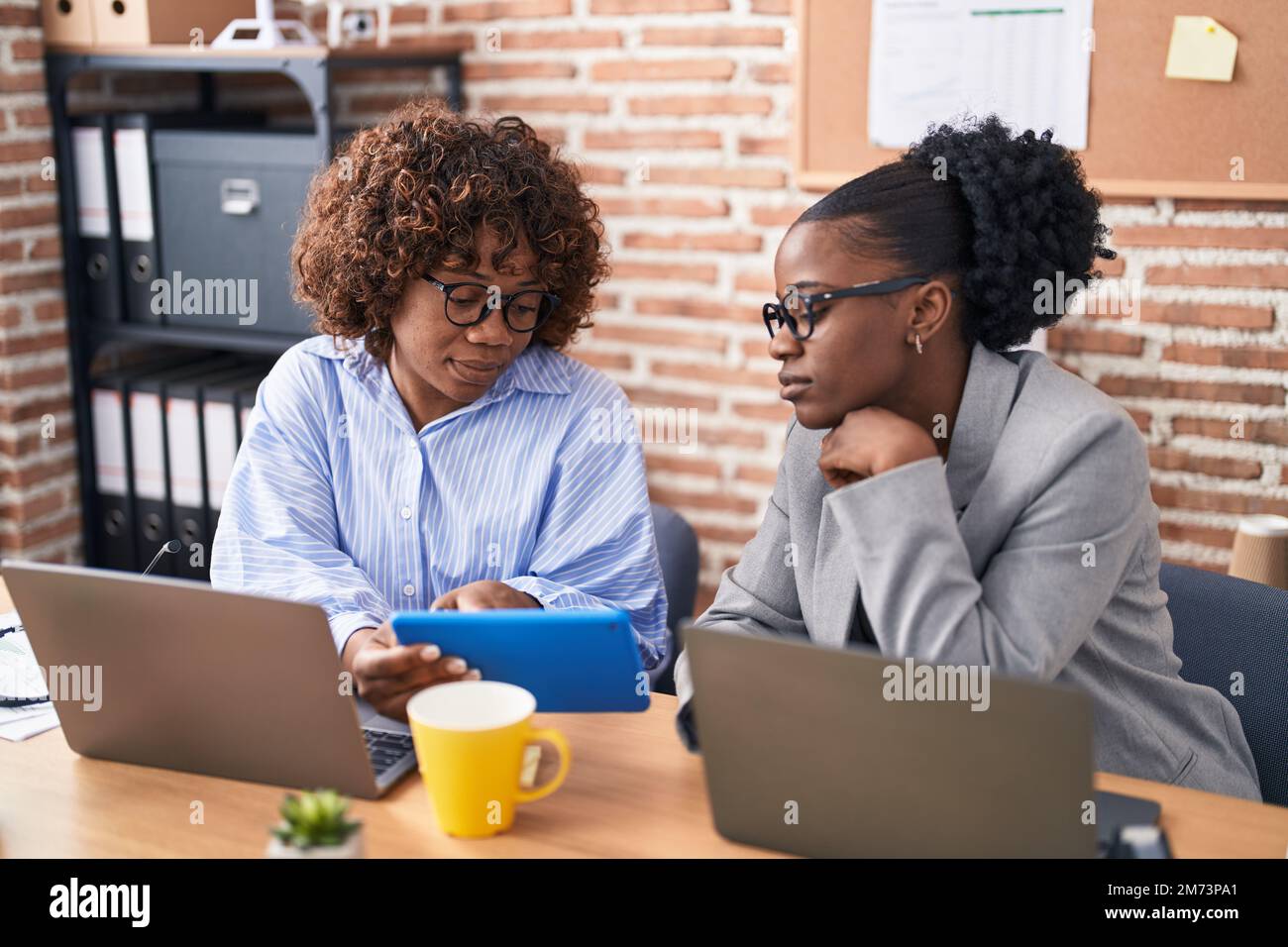 African american women business workers using touchpad working at ...