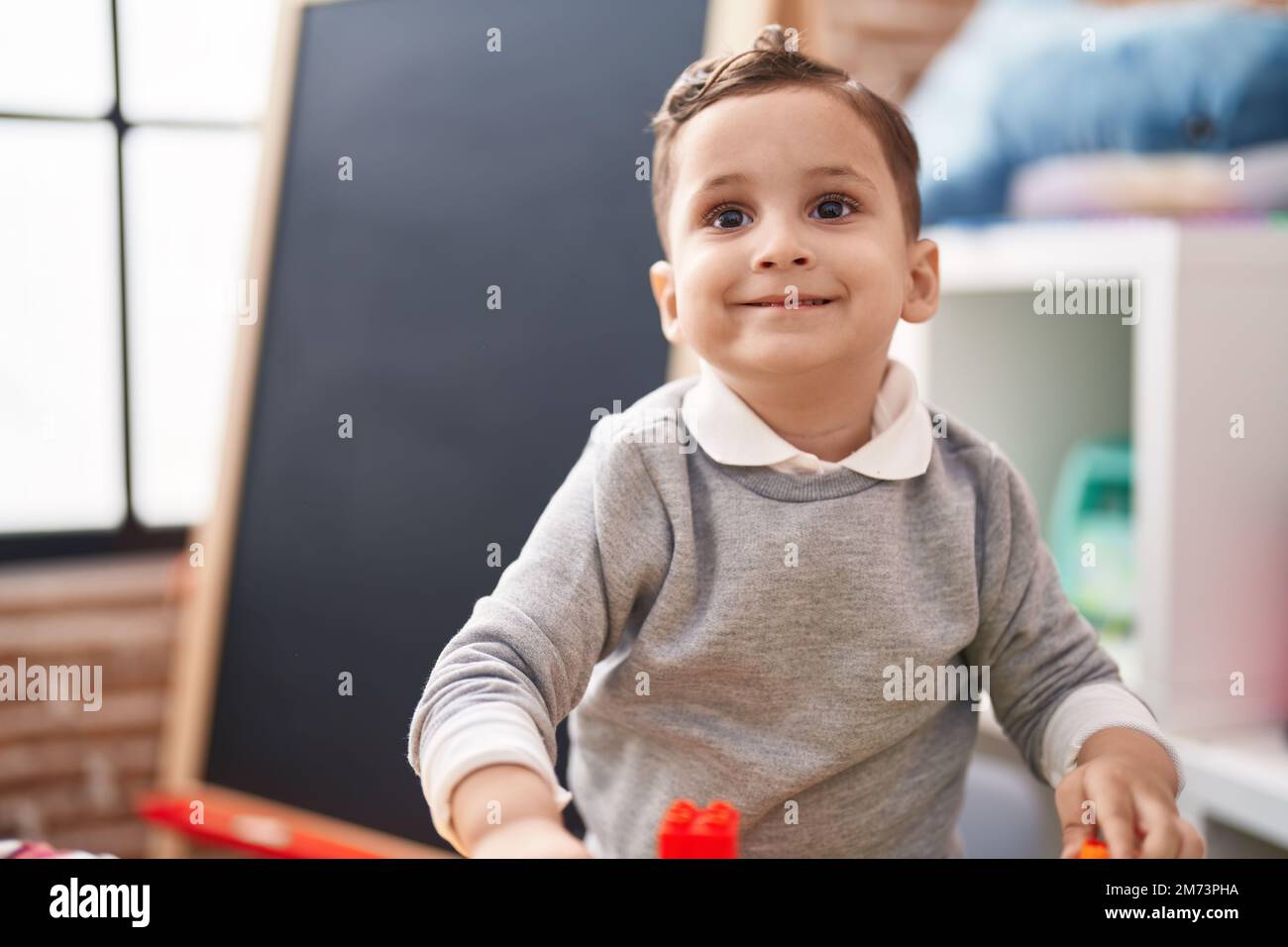 Adorable hispanic toddler smiling confident standing at kindergarten ...