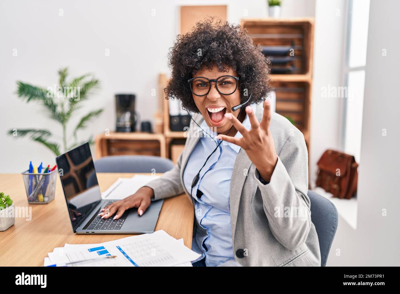 Black woman with curly hair wearing call center agent headset at the ...