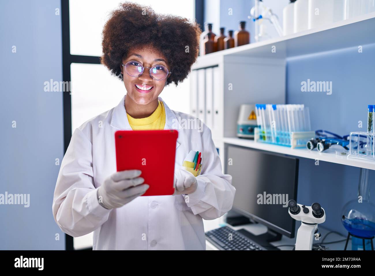 African american woman scientist using touchpad working at laboratory ...