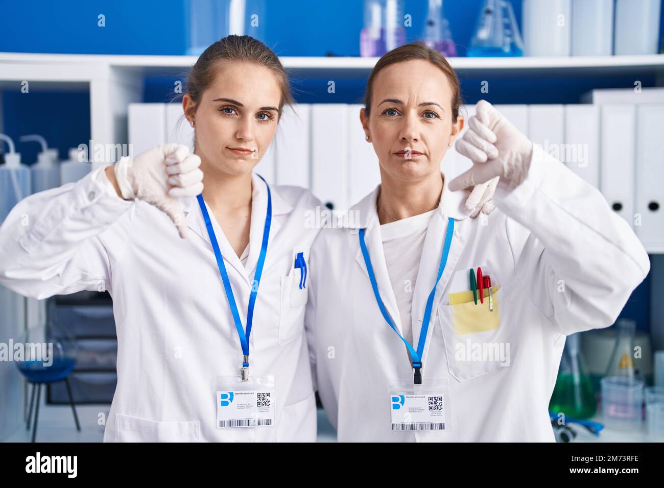 Two women working at scientist laboratory with angry face, negative ...