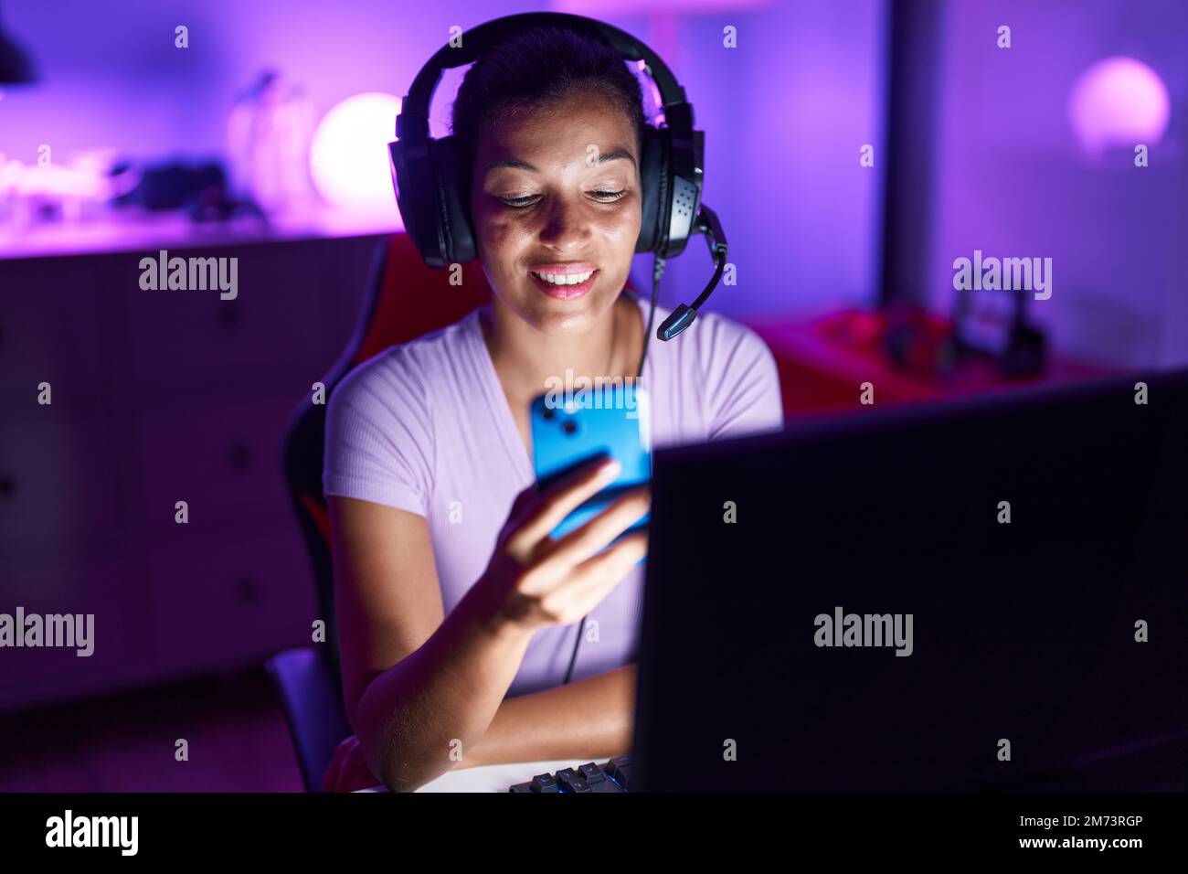 Young beautiful hispanic woman streamer using computer and smartphone ...