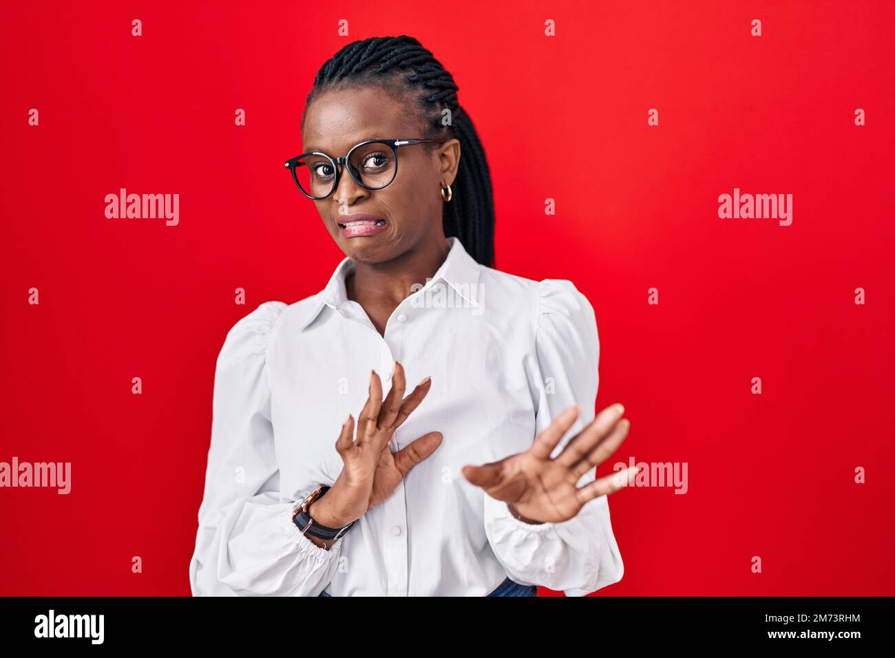 African woman with braids standing over red background disgusted ...