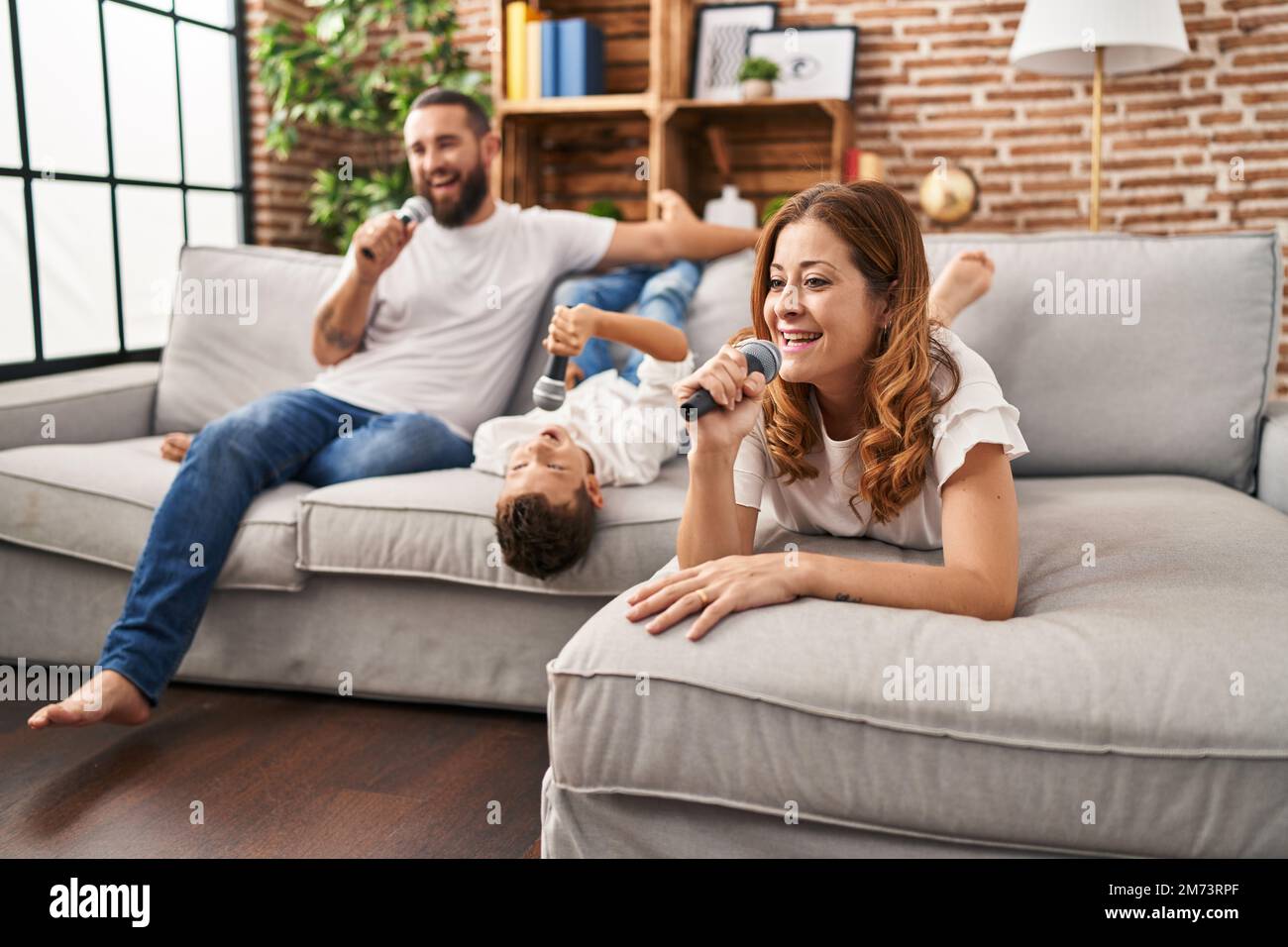 Family singing song using microphone at home Stock Photo - Alamy