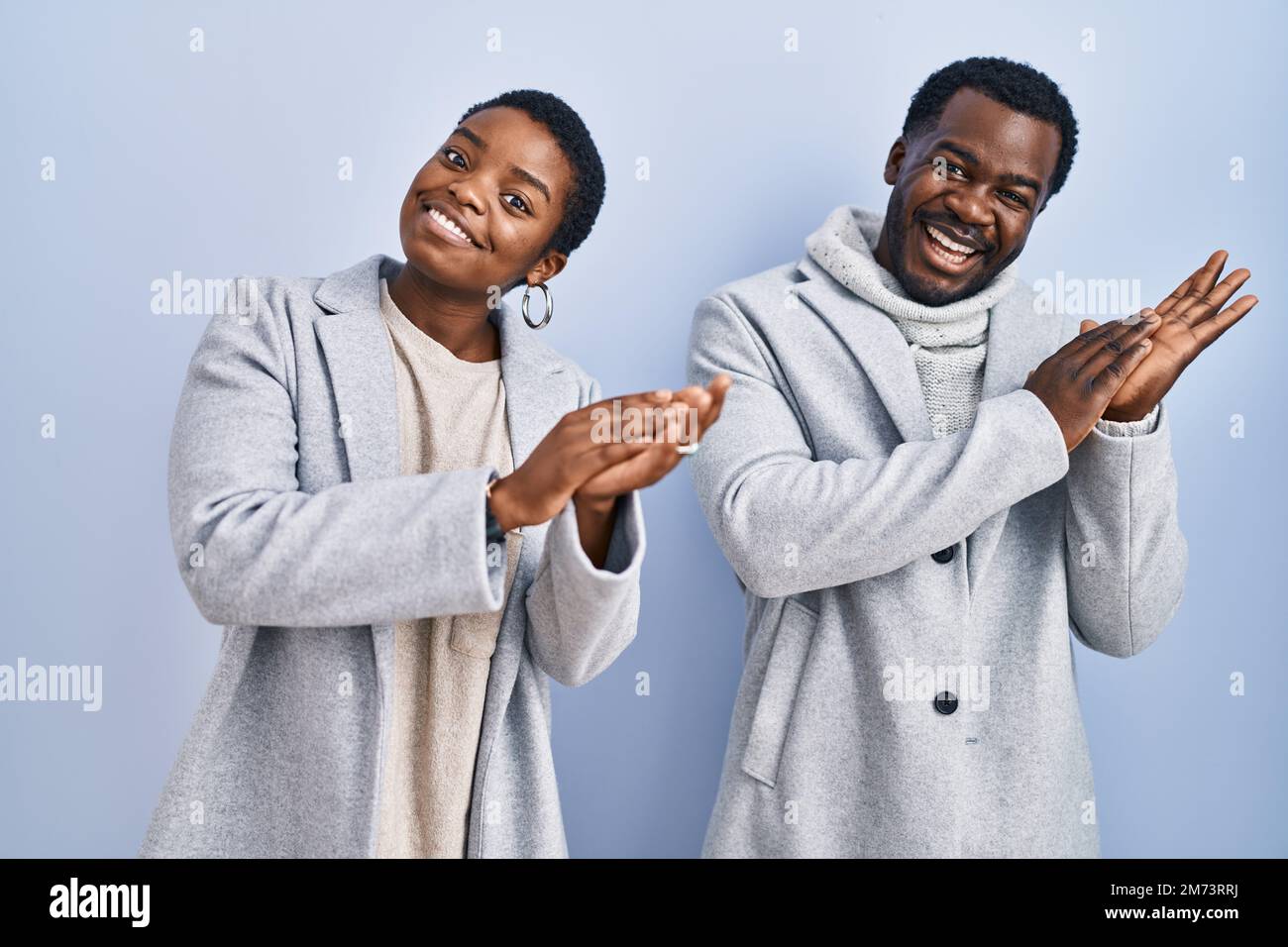 Young african american couple standing over blue background together ...