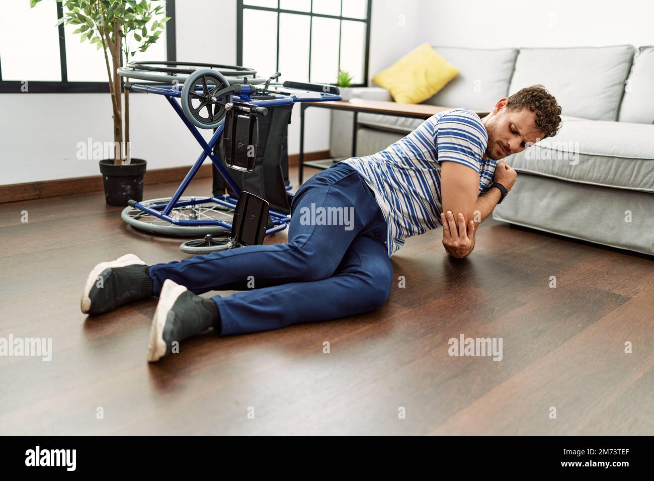 Young hispanic man lying on floor for accident at home Stock Photo - Alamy
