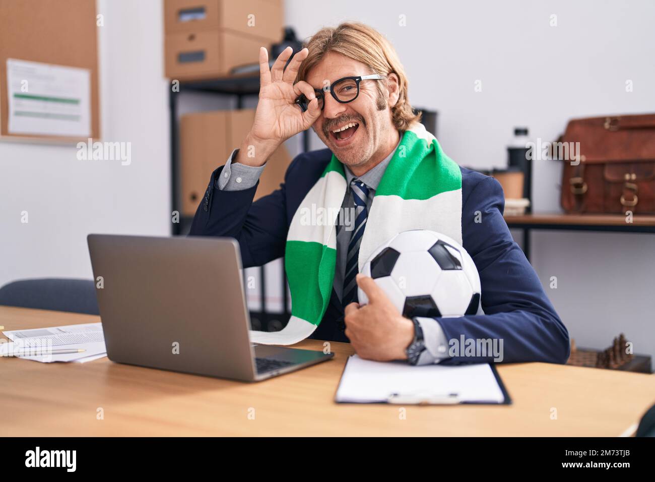 Caucasian man with mustache working at the office supporting football ...