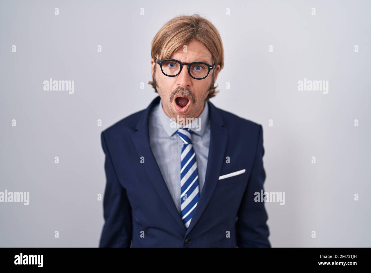 Caucasian man with mustache wearing business clothes in shock face ...