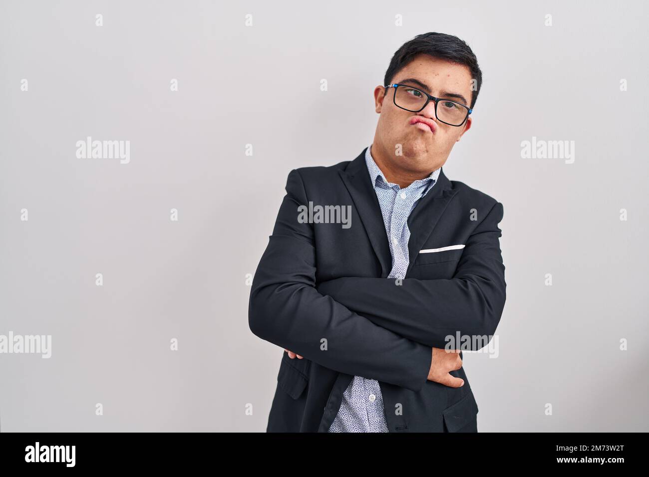 Young hispanic man with down syndrome wearing business style skeptic ...