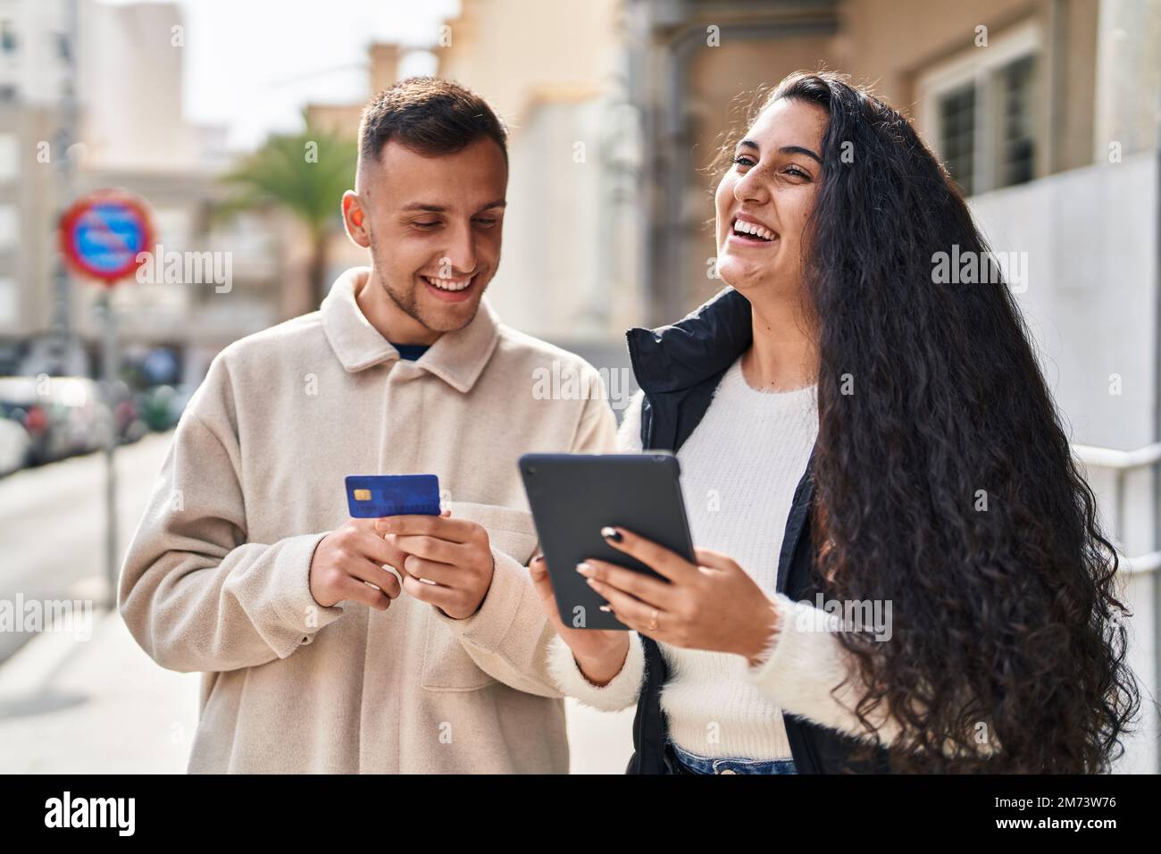 Man and woman smiling confident using touchpad and credit card at ...
