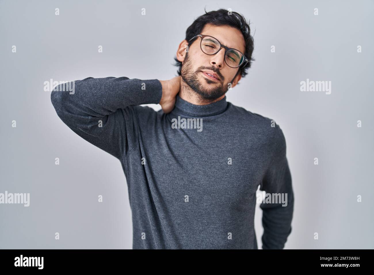 Handsome latin man standing over isolated background suffering of neck ...