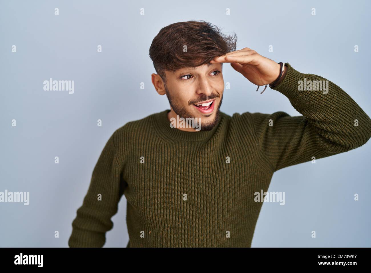 Arab man with beard standing over blue background very happy and ...