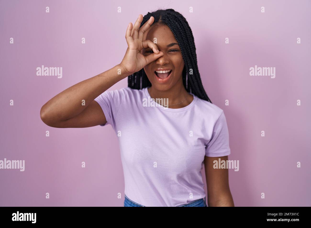 African american woman with braids standing over pink background doing ...