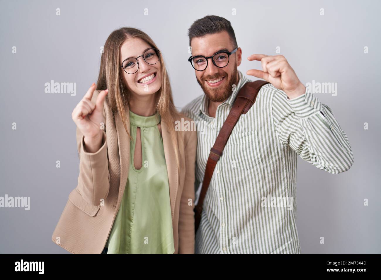 Young couple standing over white background smiling and confident ...