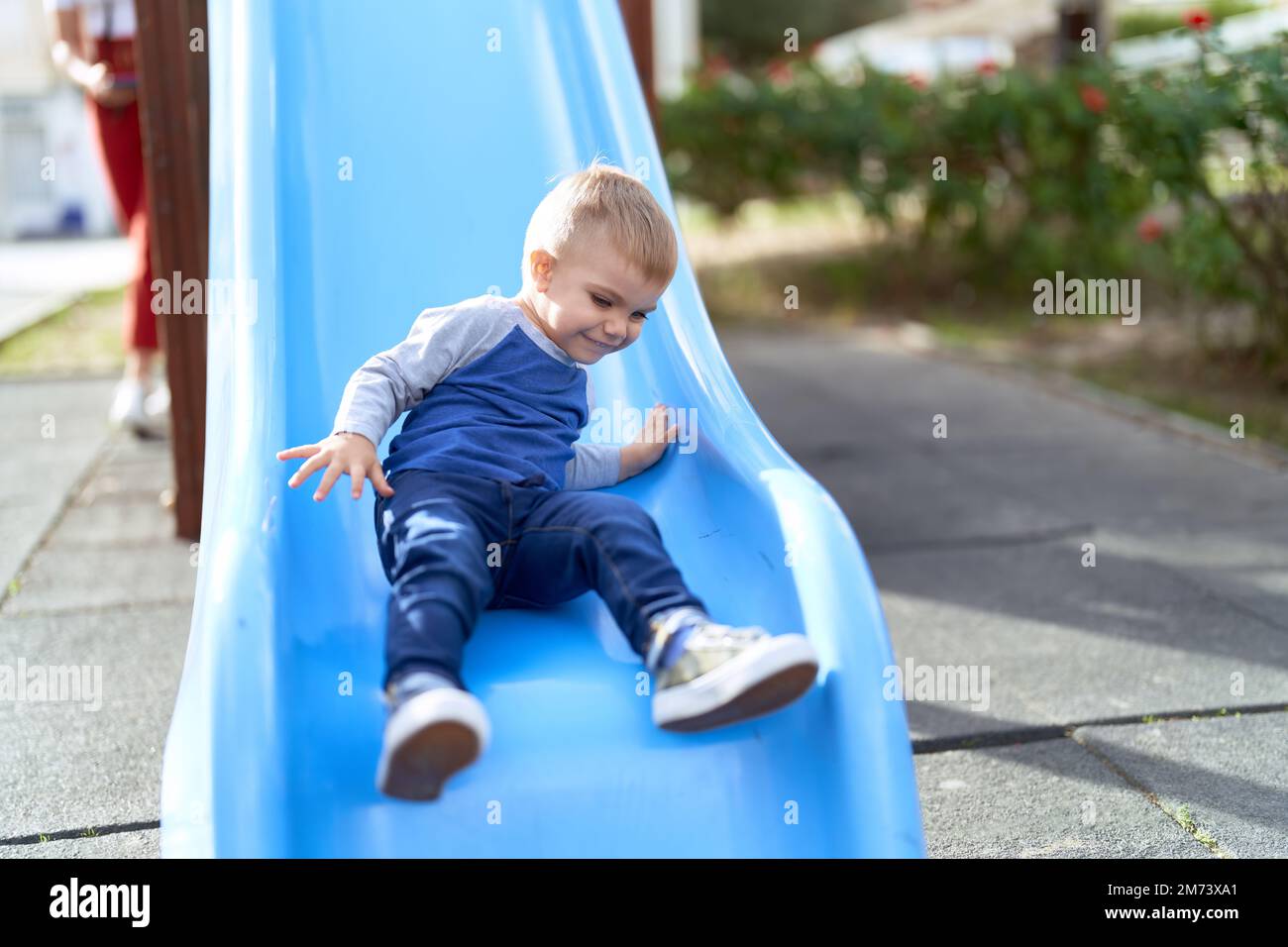 Adorable toddler smiling confident playing on slide at park playground Stock Photo - Alamy