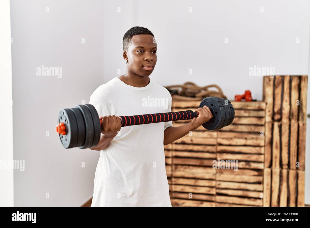 Young african man training with dumbbells at the gym Stock Photo - Alamy