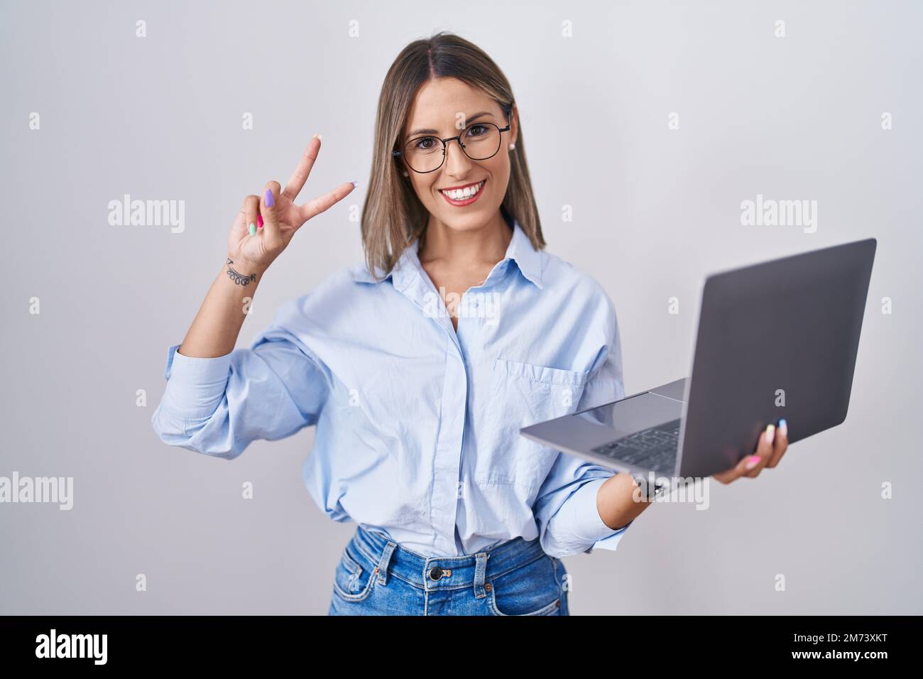 Young woman working using computer laptop smiling looking to the camera ...