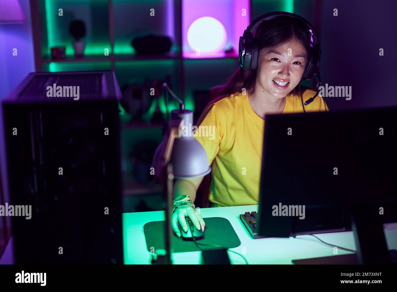 Chinese woman streamer smiling confident using computer at gaming room ...