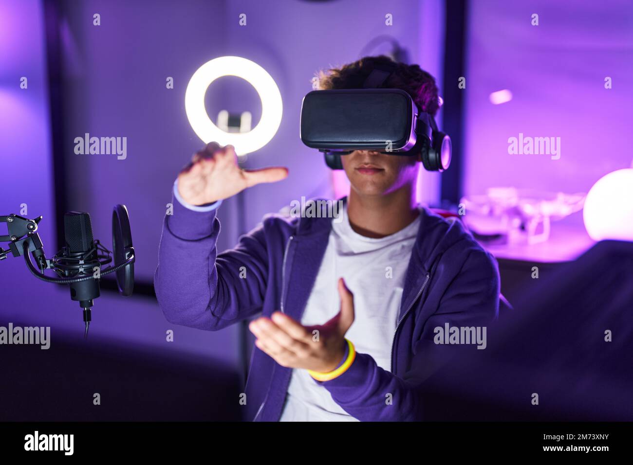 Young Hispanic Teenager Streamer Playing Video Game Using Virtual Reality Glasses At Gaming Room 