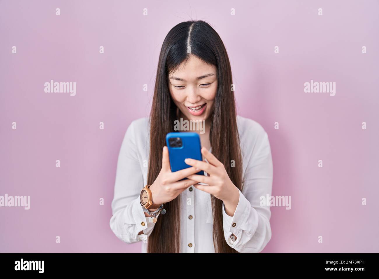 Chinese young woman using smartphone typing message smiling and ...