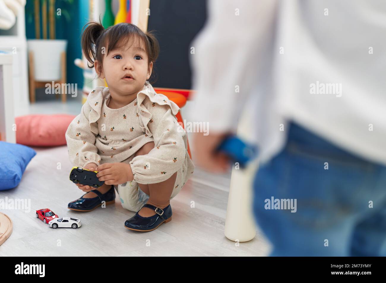 Adorable chinese girl playing with cars toy at kindergarten Stock Photo ...