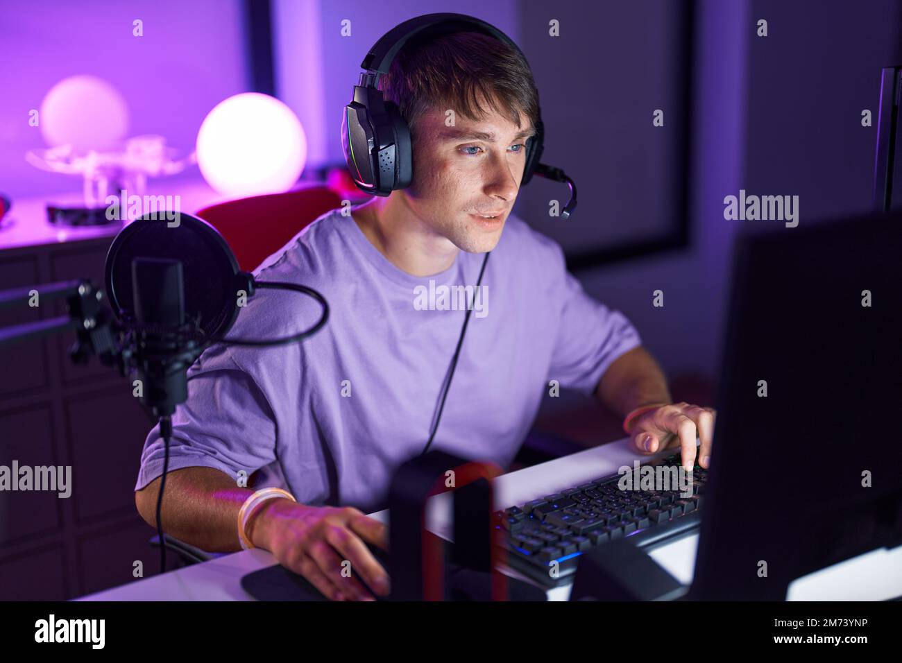 Young caucasian man streamer playing video game using computer at ...