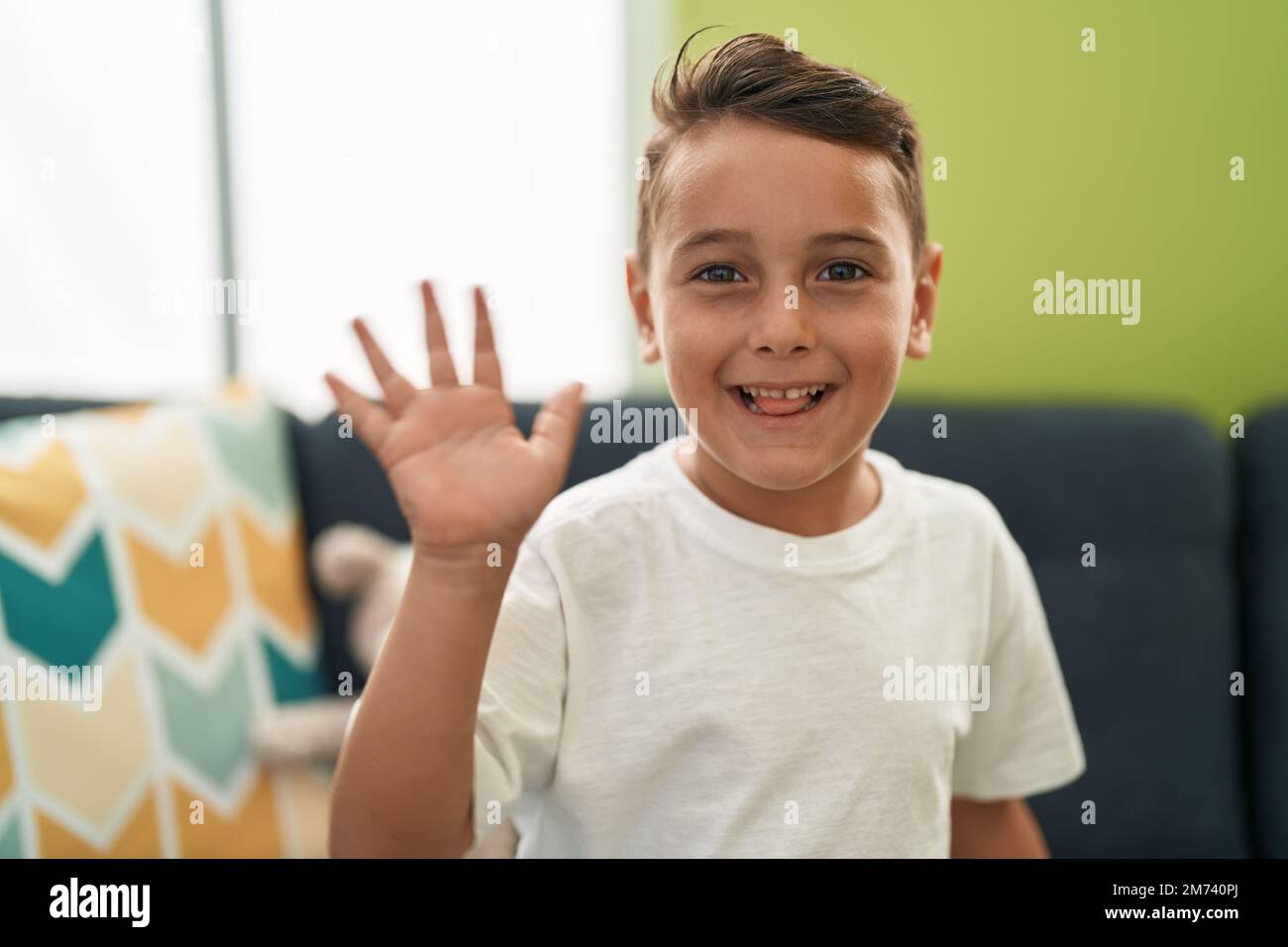 Adorable hispanic toddler smiling confident saying hello with hand at ...