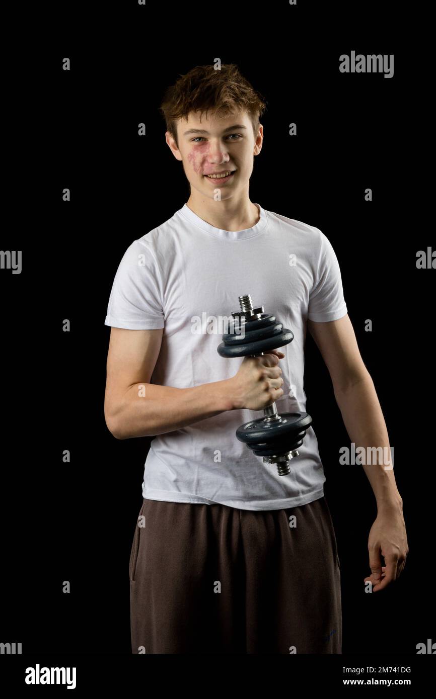 17 year olf teen boy using a dumbbell Stock Photo - Alamy