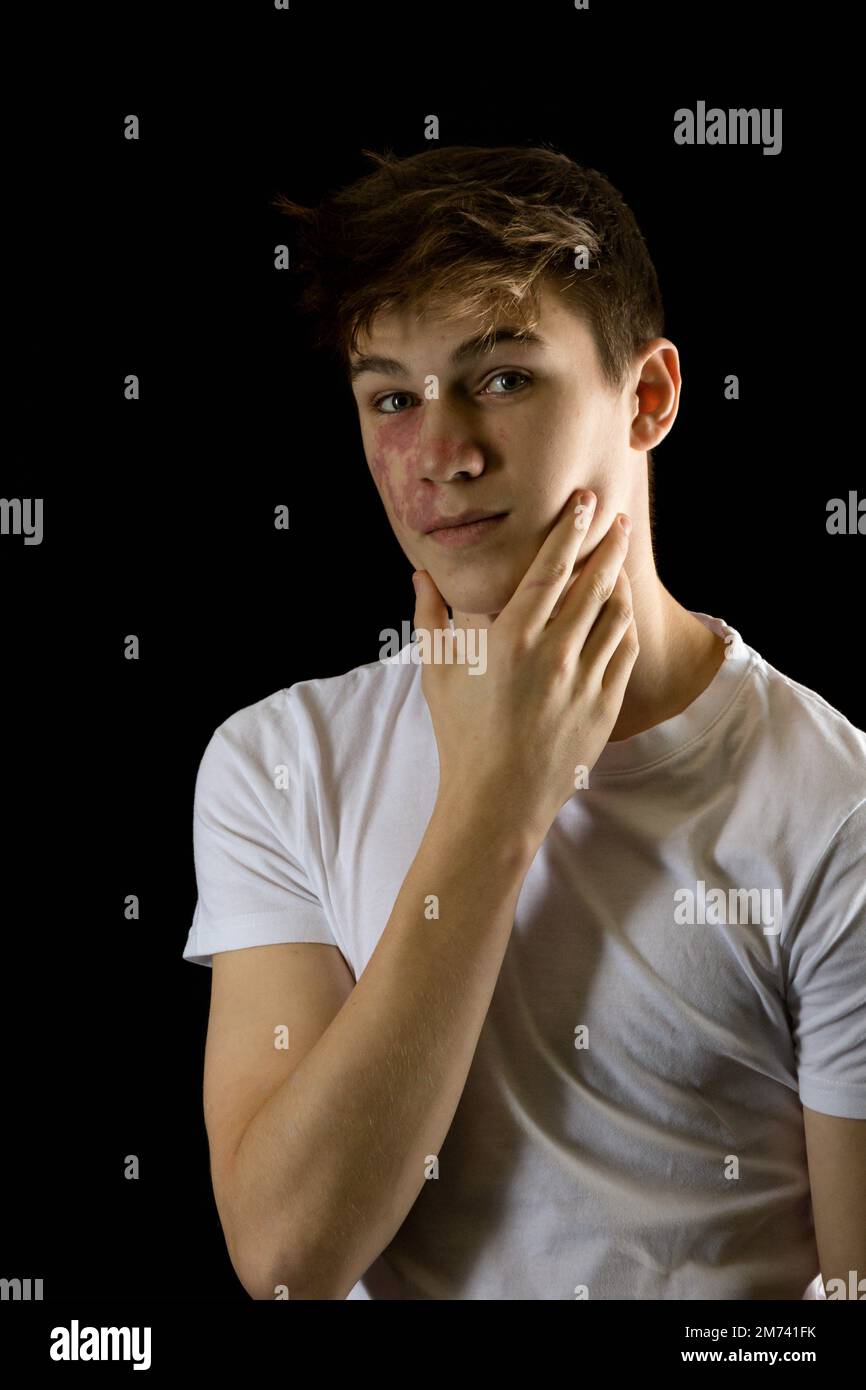 A 17 year old teen boy rubbing his chin Stock Photo - Alamy