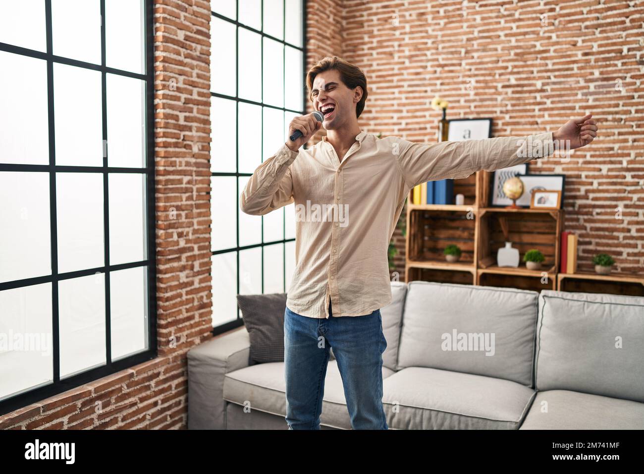 Young caucasian man singing song standing at home Stock Photo - Alamy