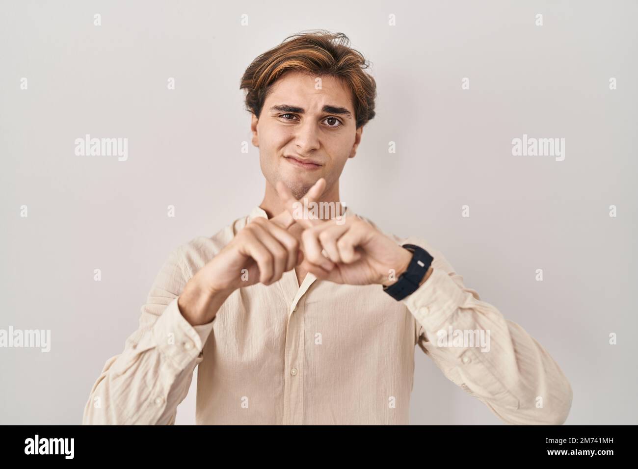 Young man standing over isolated background rejection expression ...