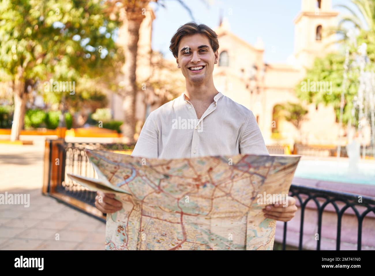 Young caucasian man smiling confident holding city map at park Stock ...