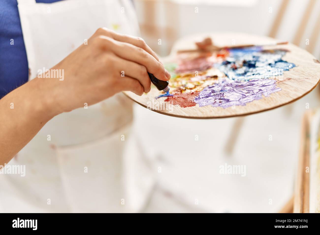 Young latin woman mixing color on palette at art studio Stock Photo - Alamy