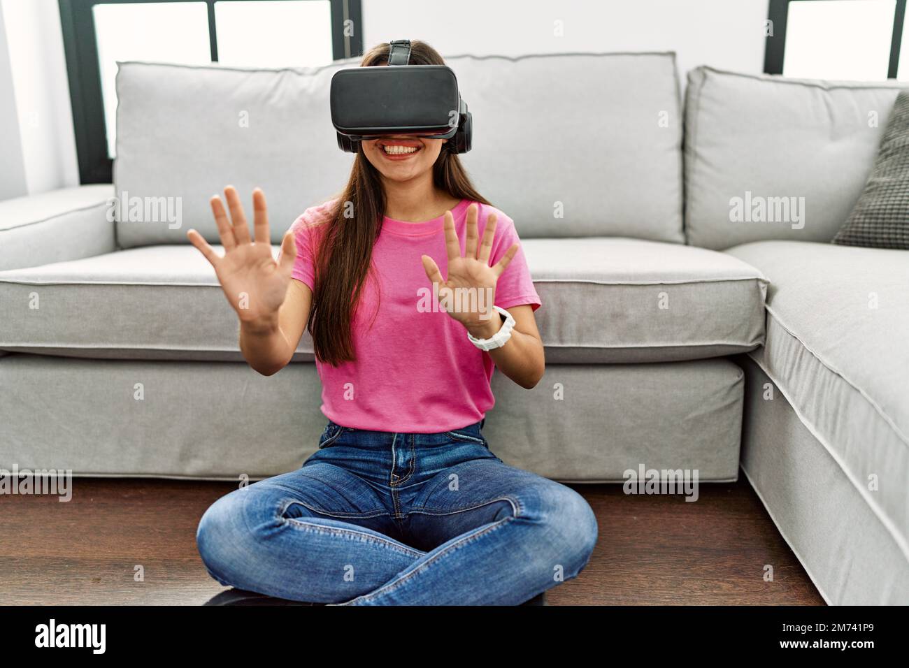 Young latin woman playing video game using vr goggles at home Stock ...
