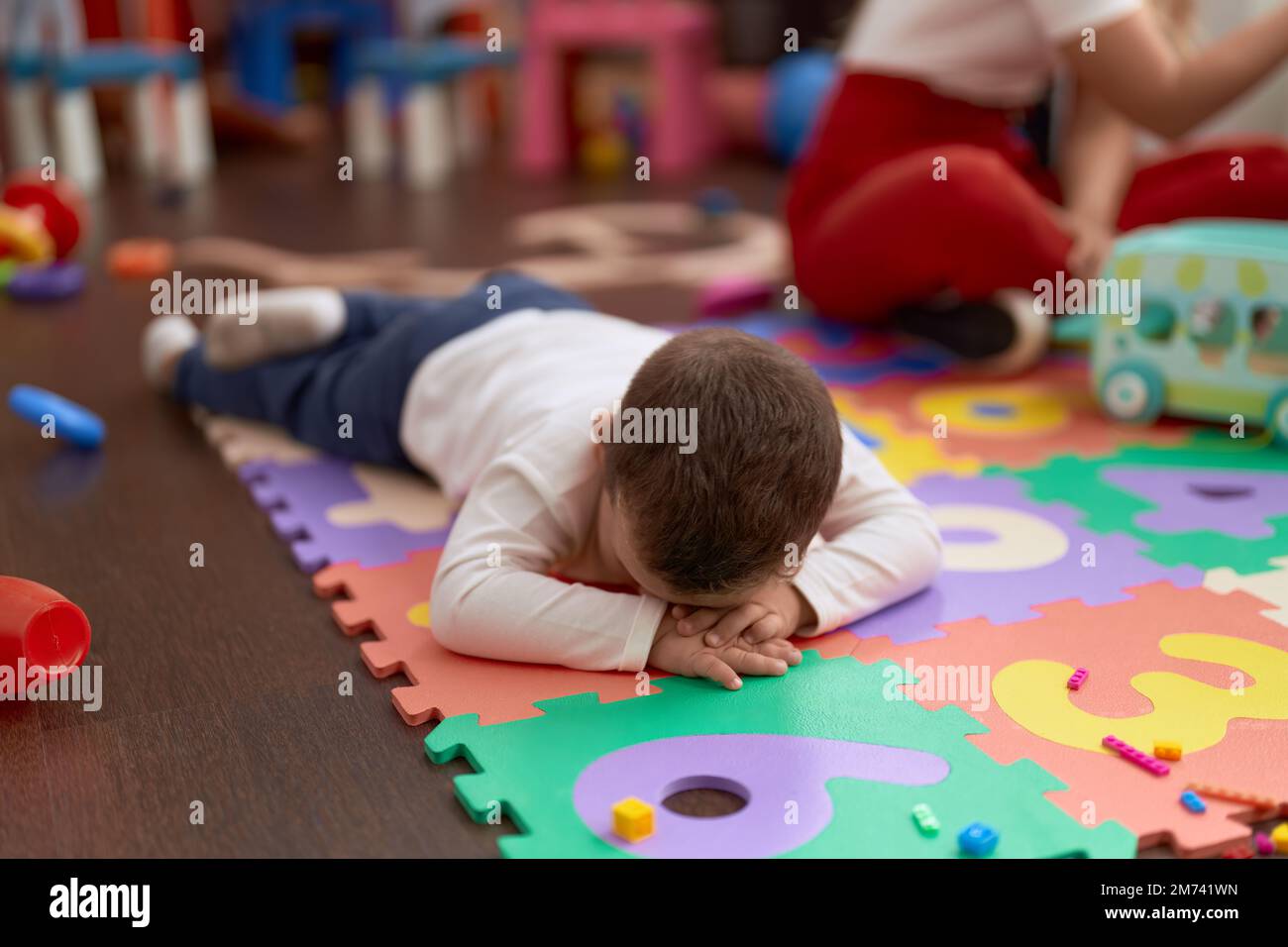 Adorable toddler lying on floor crying at kindergarten Stock Photo - Alamy